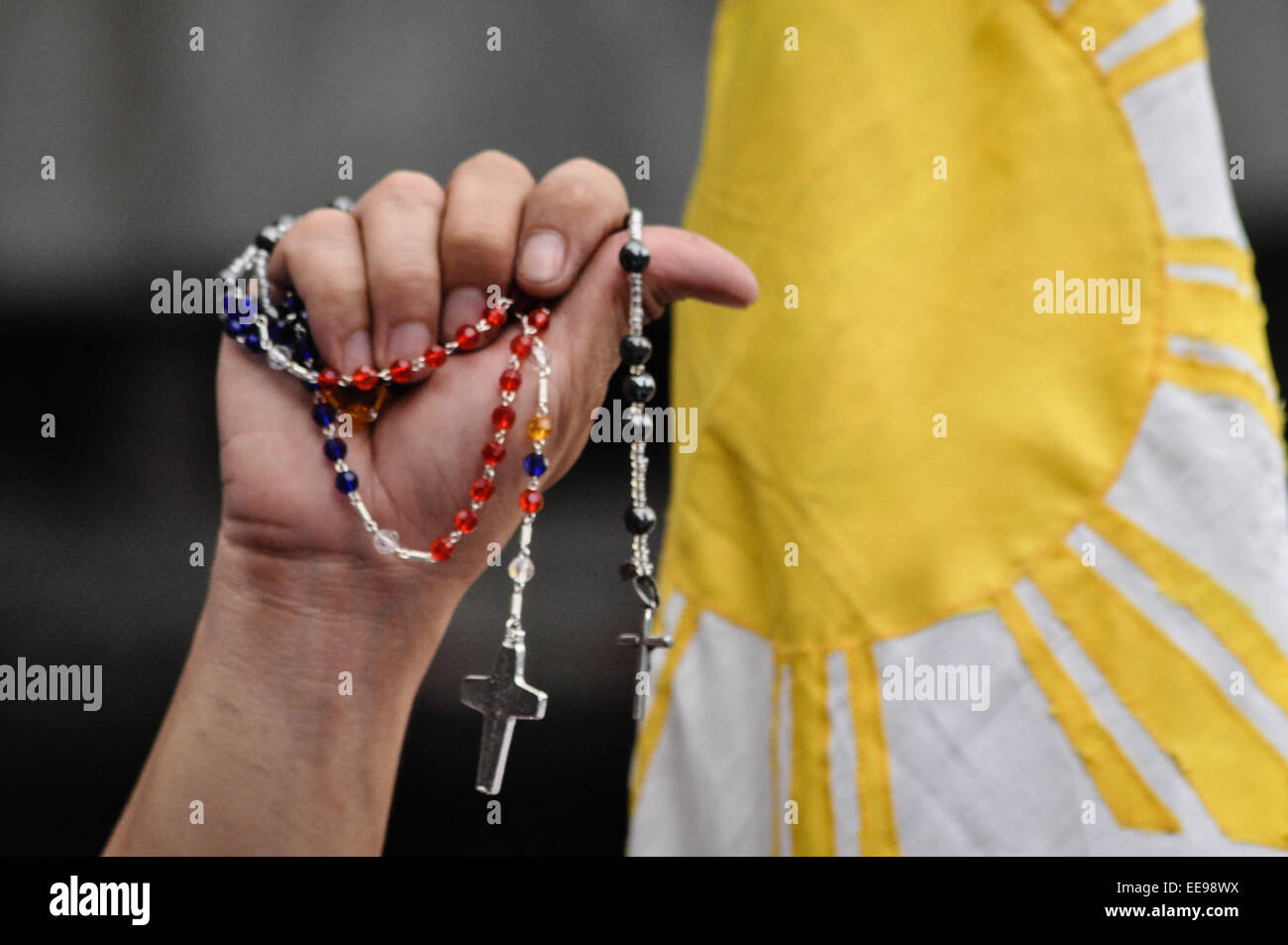 A Filipino Catholic holds a rosary as he waits for the arrival of Pope ...