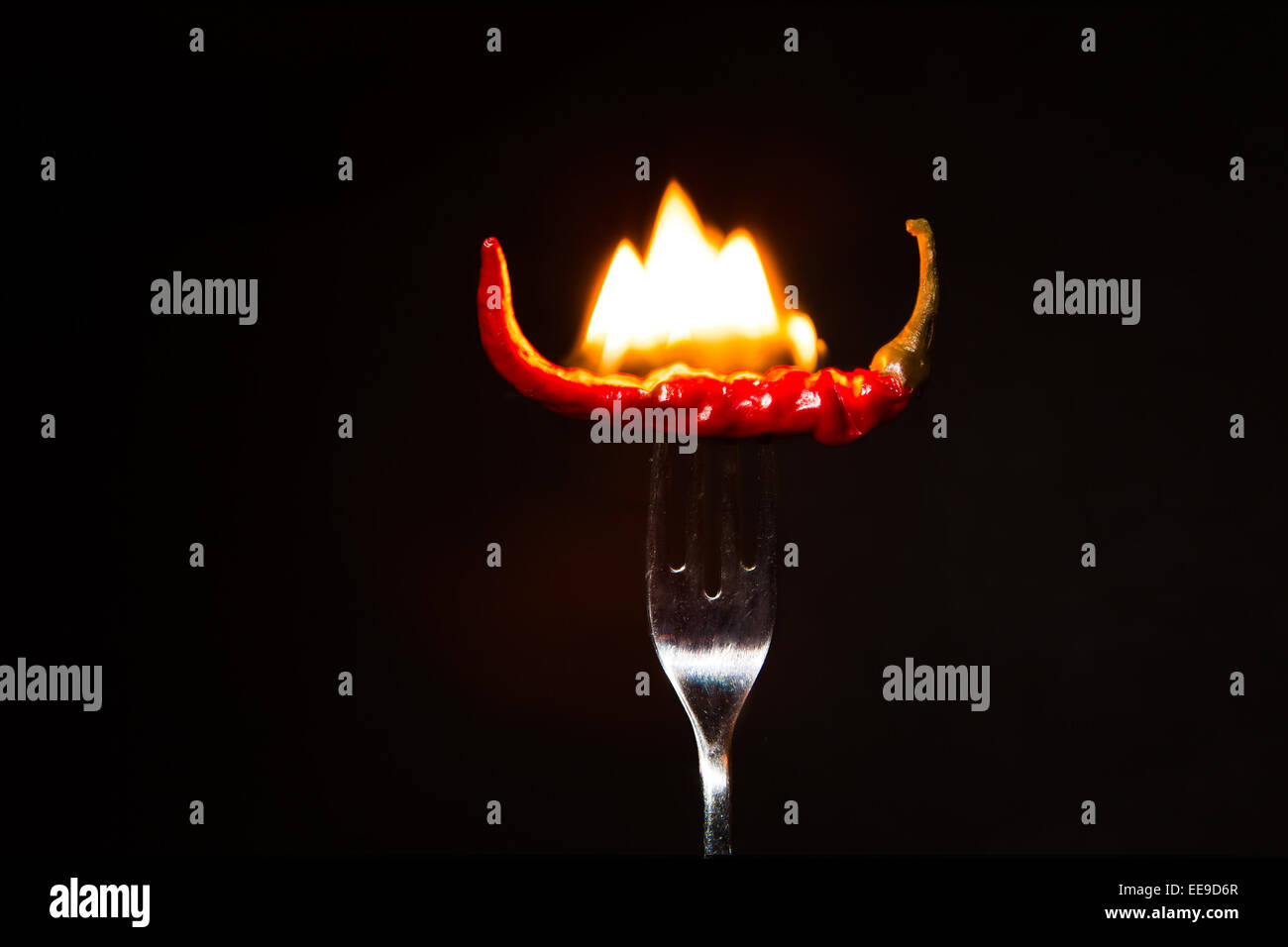 Red hot chili pepper on fire on black background Stock Photo - Alamy