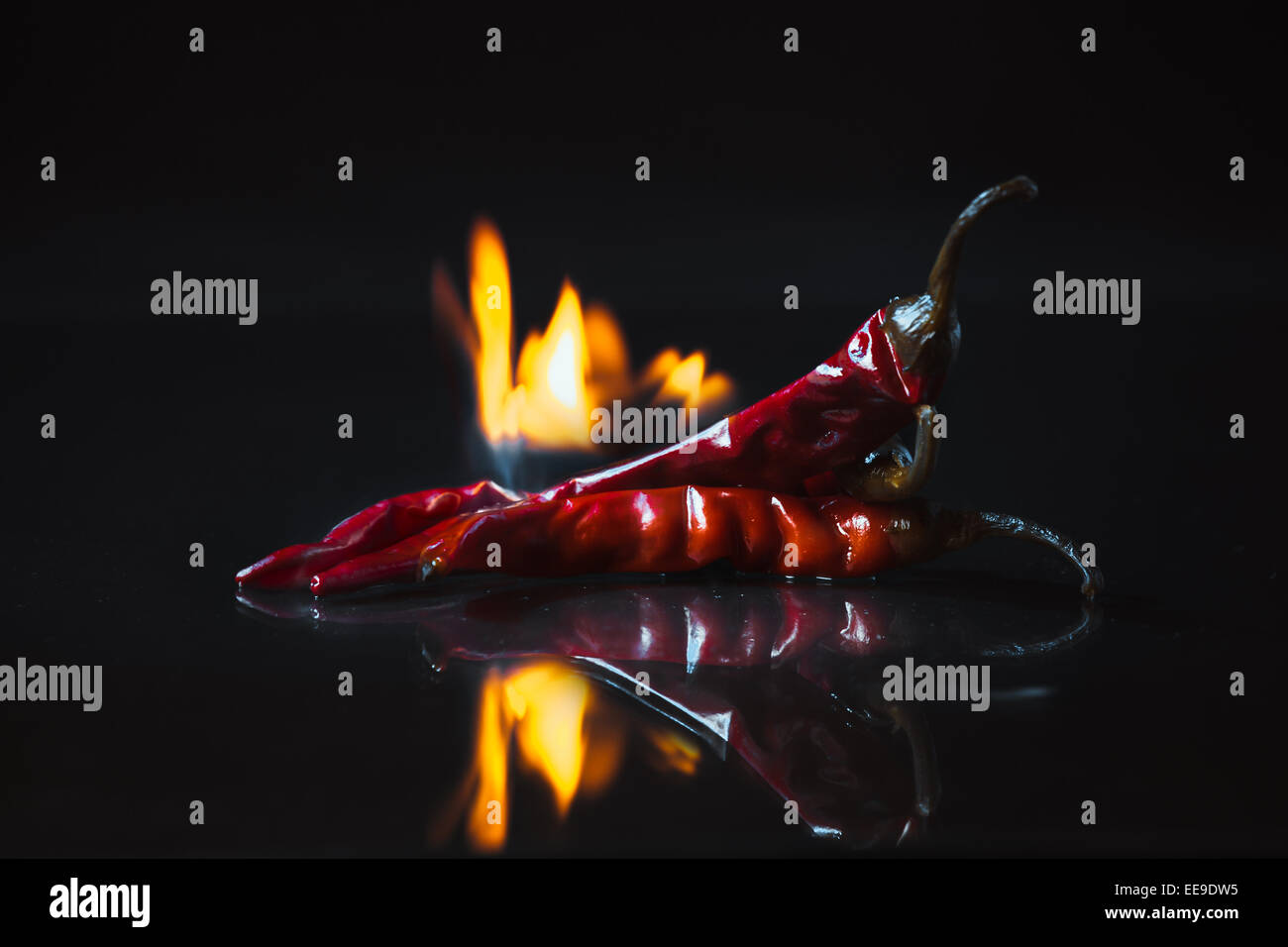 Red hot chili pepper on fire on black background Stock Photo - Alamy