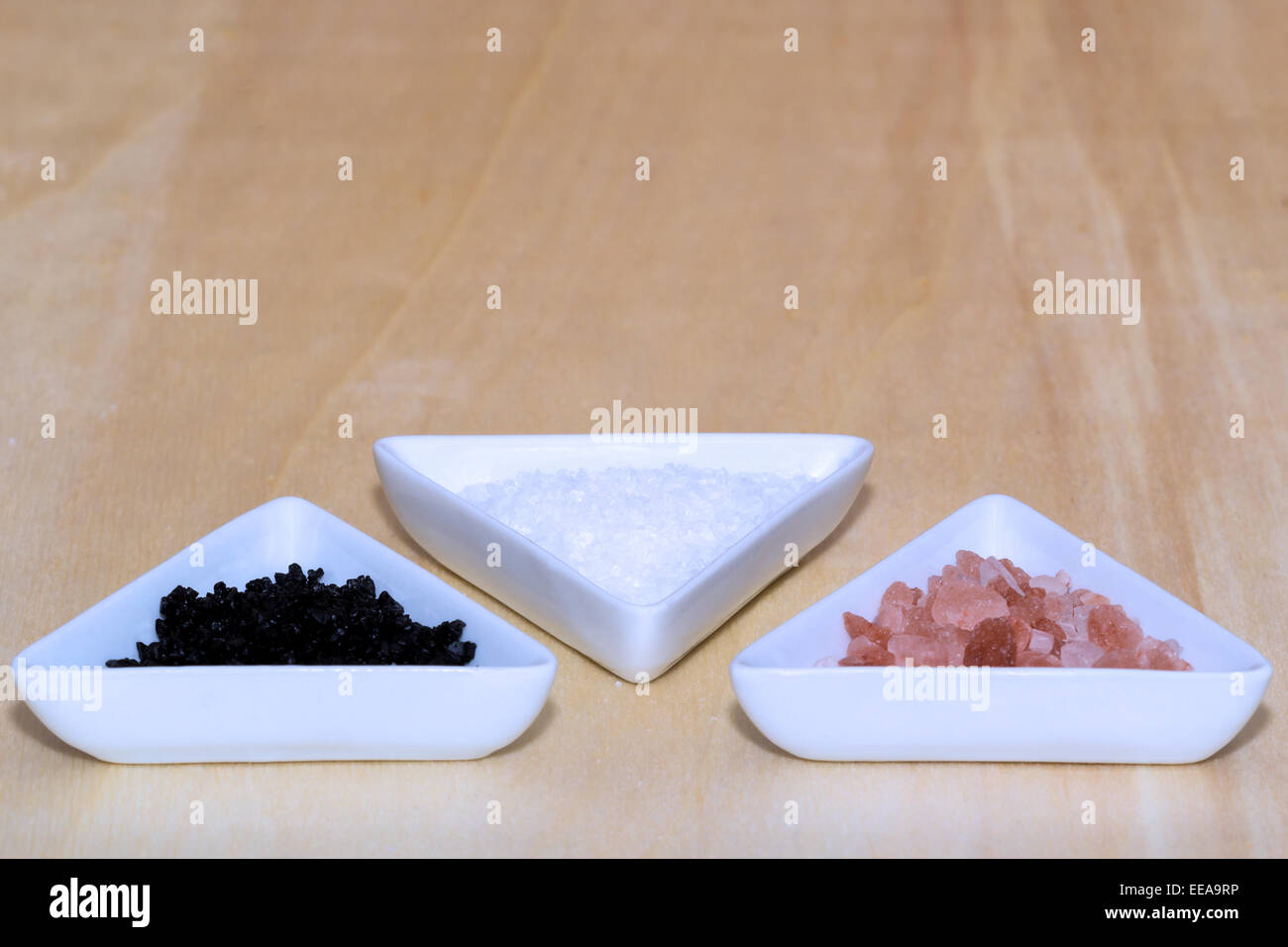 Three types of salt in white triangular shaped ceramic bowls Stock ...