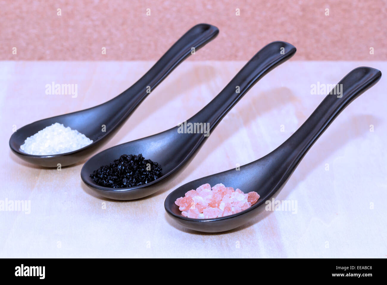 Three types of salt on black spoons Stock Photo - Alamy