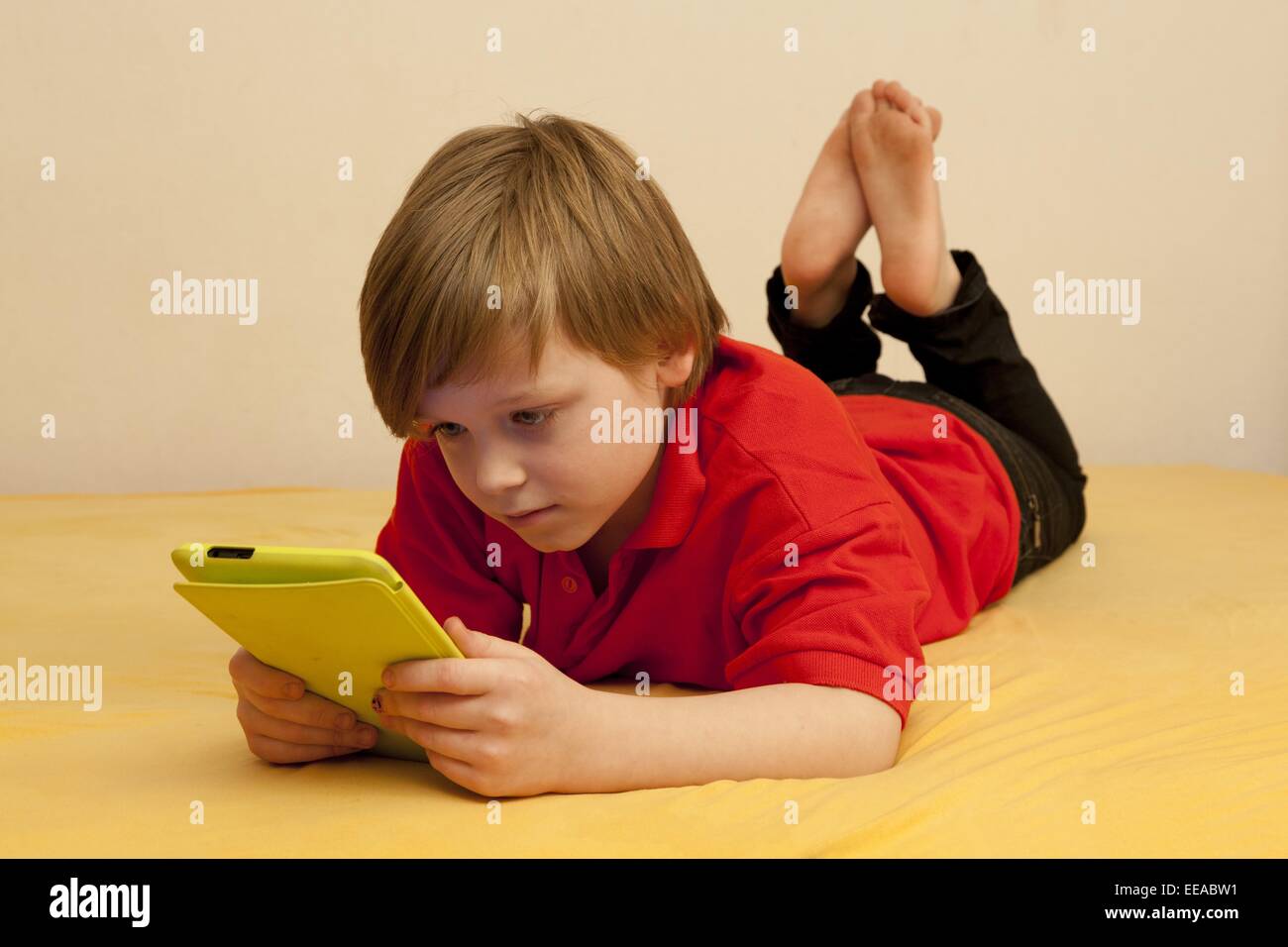 young boy playing with his tablet PC Stock Photo - Alamy
