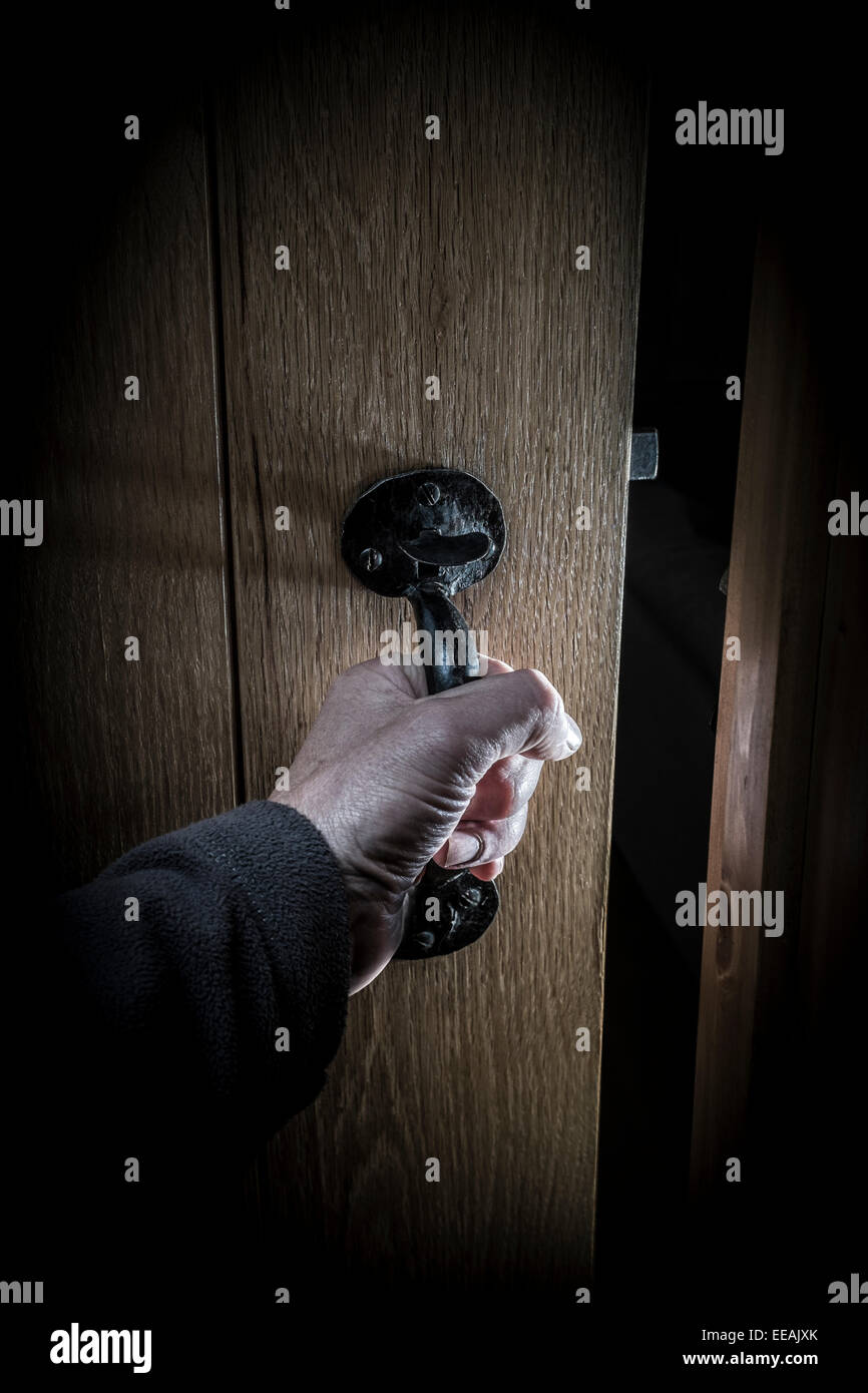 A man's hand opening a door into a dark room Stock Photo - Alamy