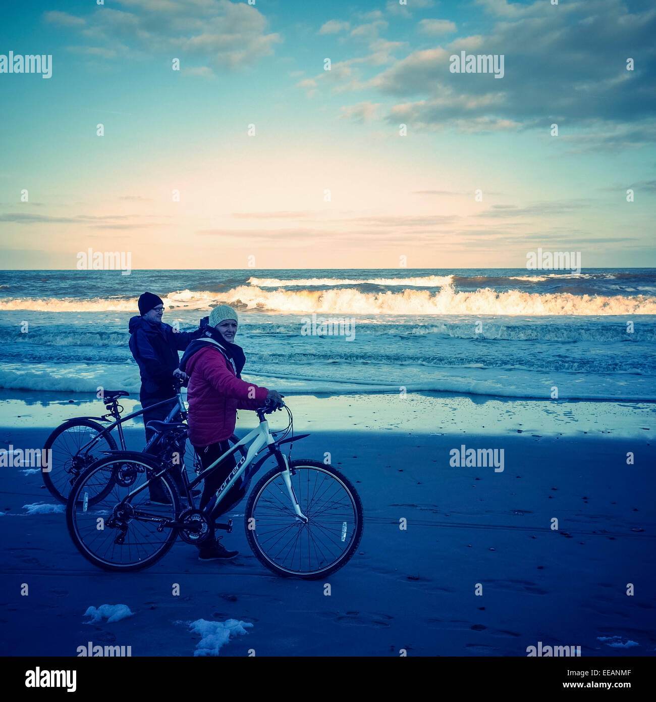 Two People with Cycles on Norfolk Beach in Winter Stock Photo - Alamy