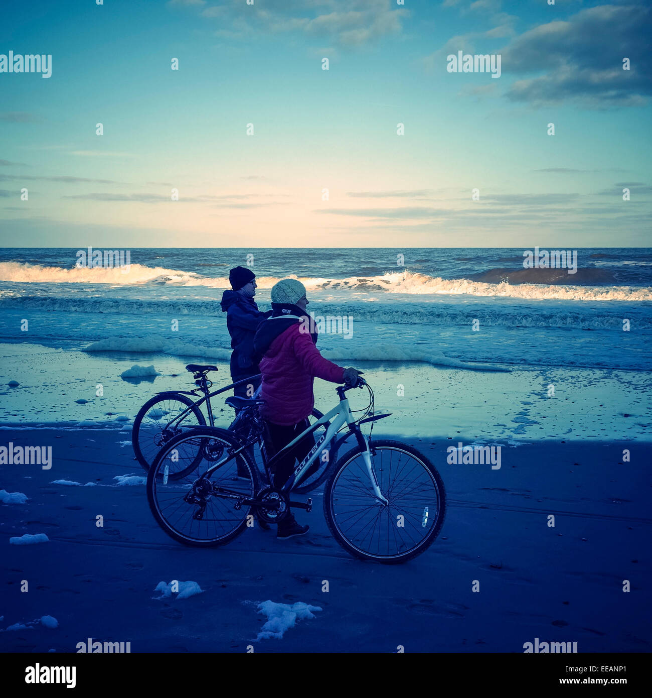 Two People with Cycles on Norfolk Beach in Winter Stock Photo - Alamy