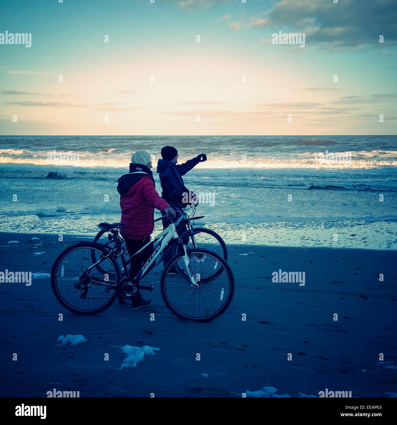 Two People with Cycles on Norfolk Beach in Winter Stock Photo - Alamy