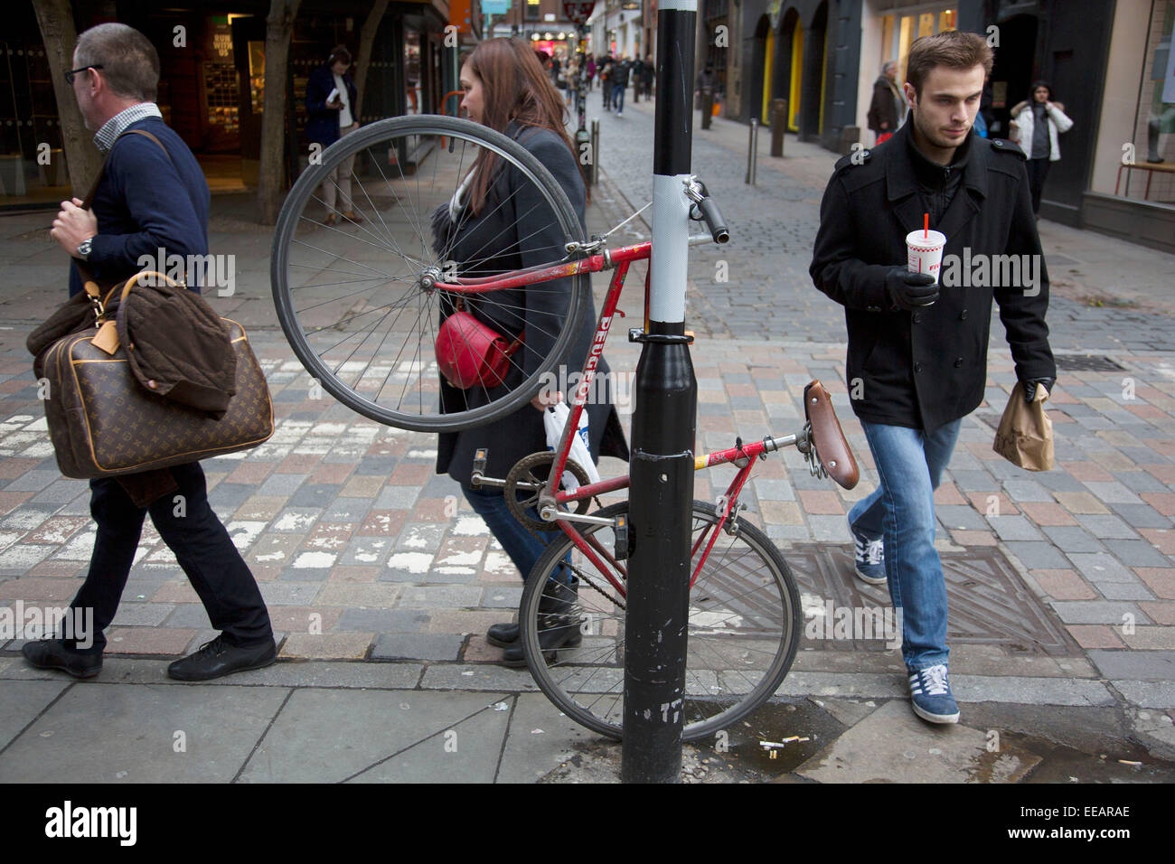 Bicycle chained to a lamppost at an awkward angle and at an ...