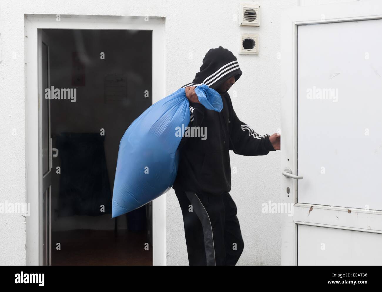 Fuldatal, Germany. 15th Jan, 2015. A refugee carries a sack through the ...