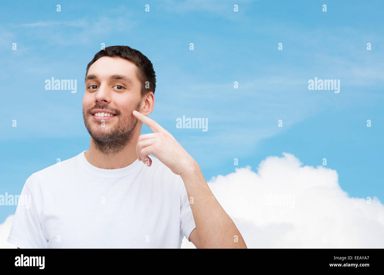 smiling young handsome man pointing to cheek Stock Photo - Alamy