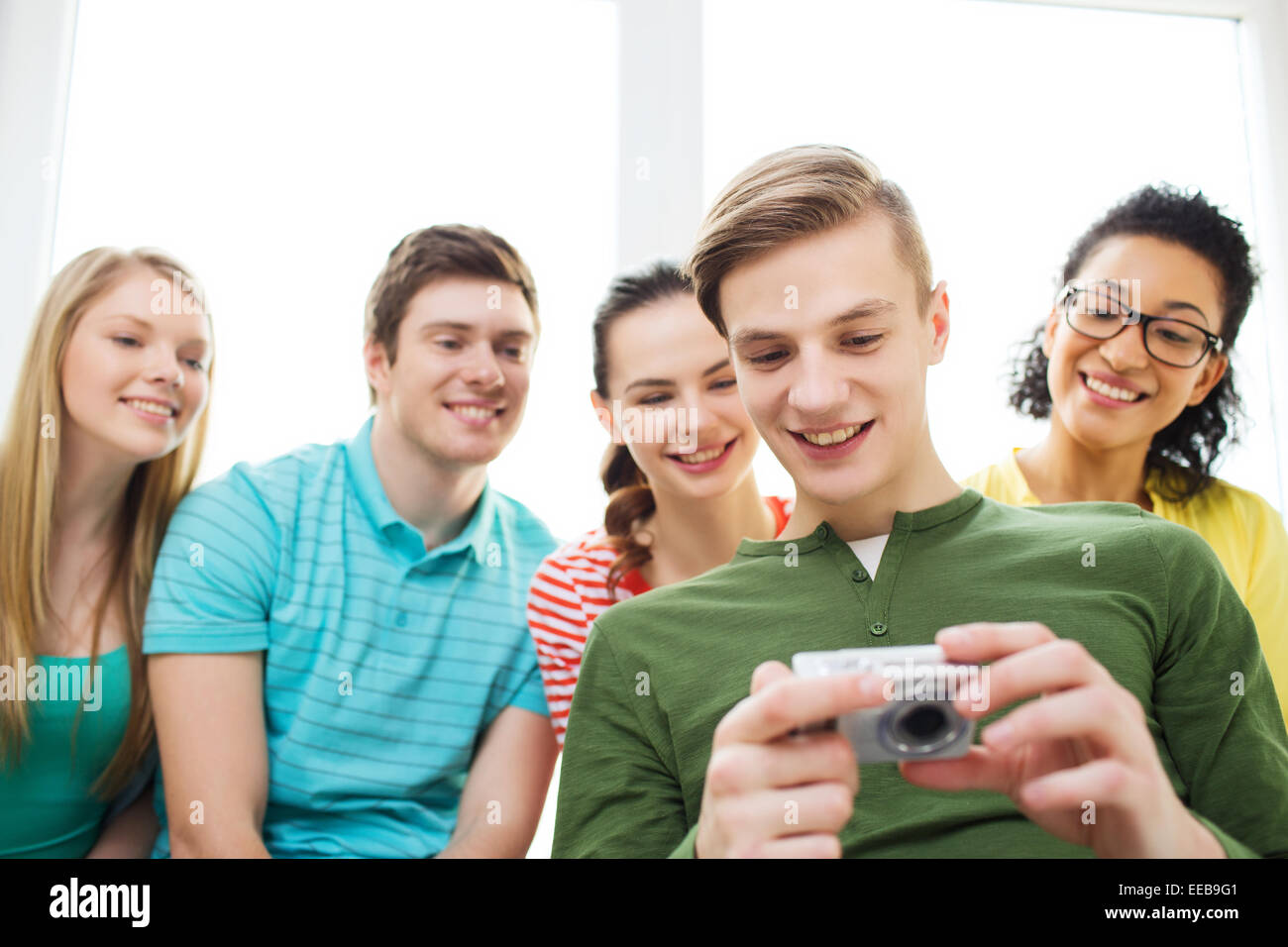 smiling students with digital camera at school Stock Photo - Alamy
