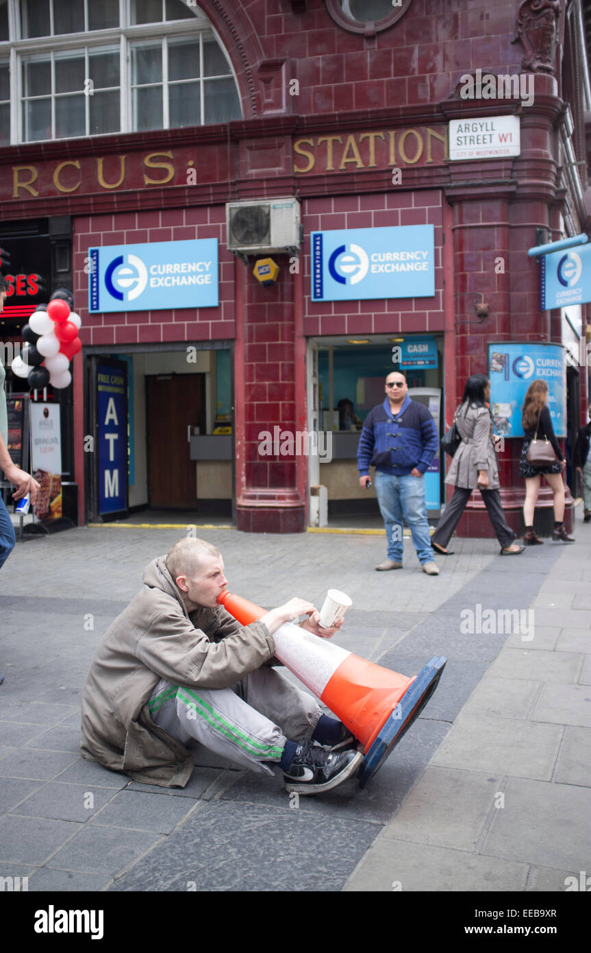 Homeless male playing music on a street cone outside Oxford Circus ...