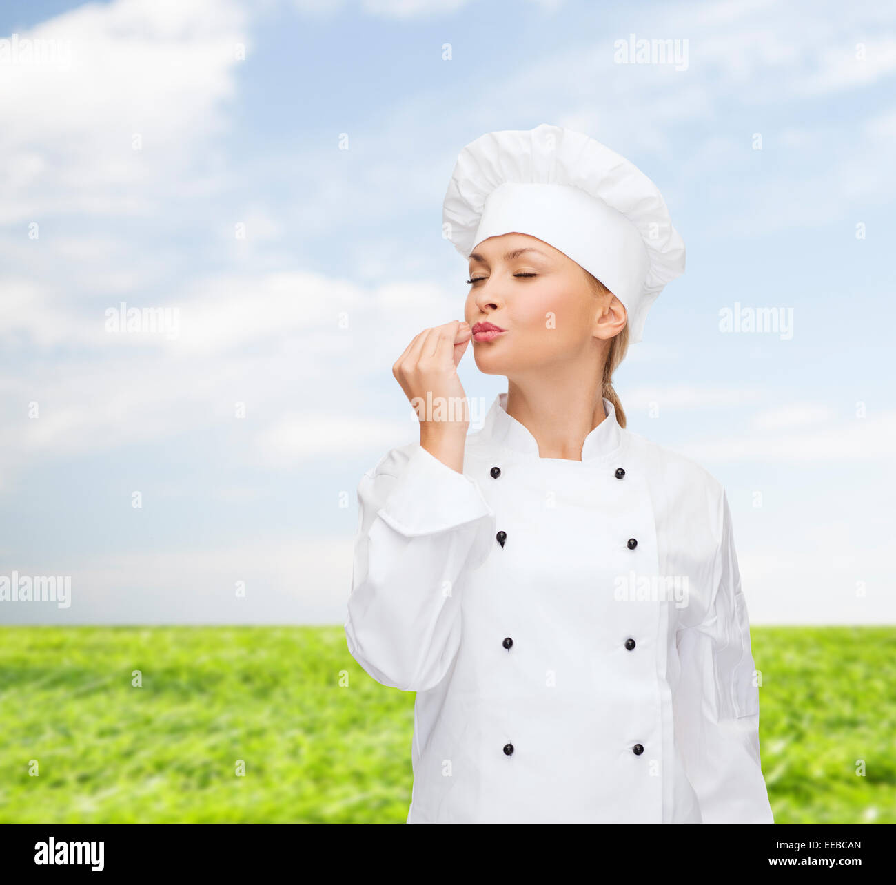 smiling female chef showing delicious sign Stock Photo - Alamy
