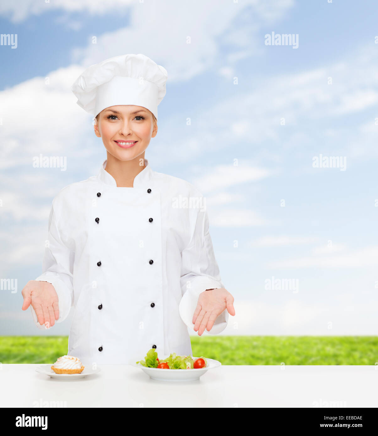 smiling female chef with salad and cake on plates Stock Photo - Alamy