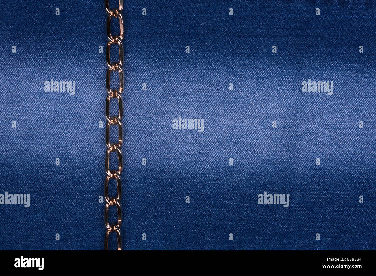 Gold chain lying on denim, can be used as background Stock Photo - Alamy