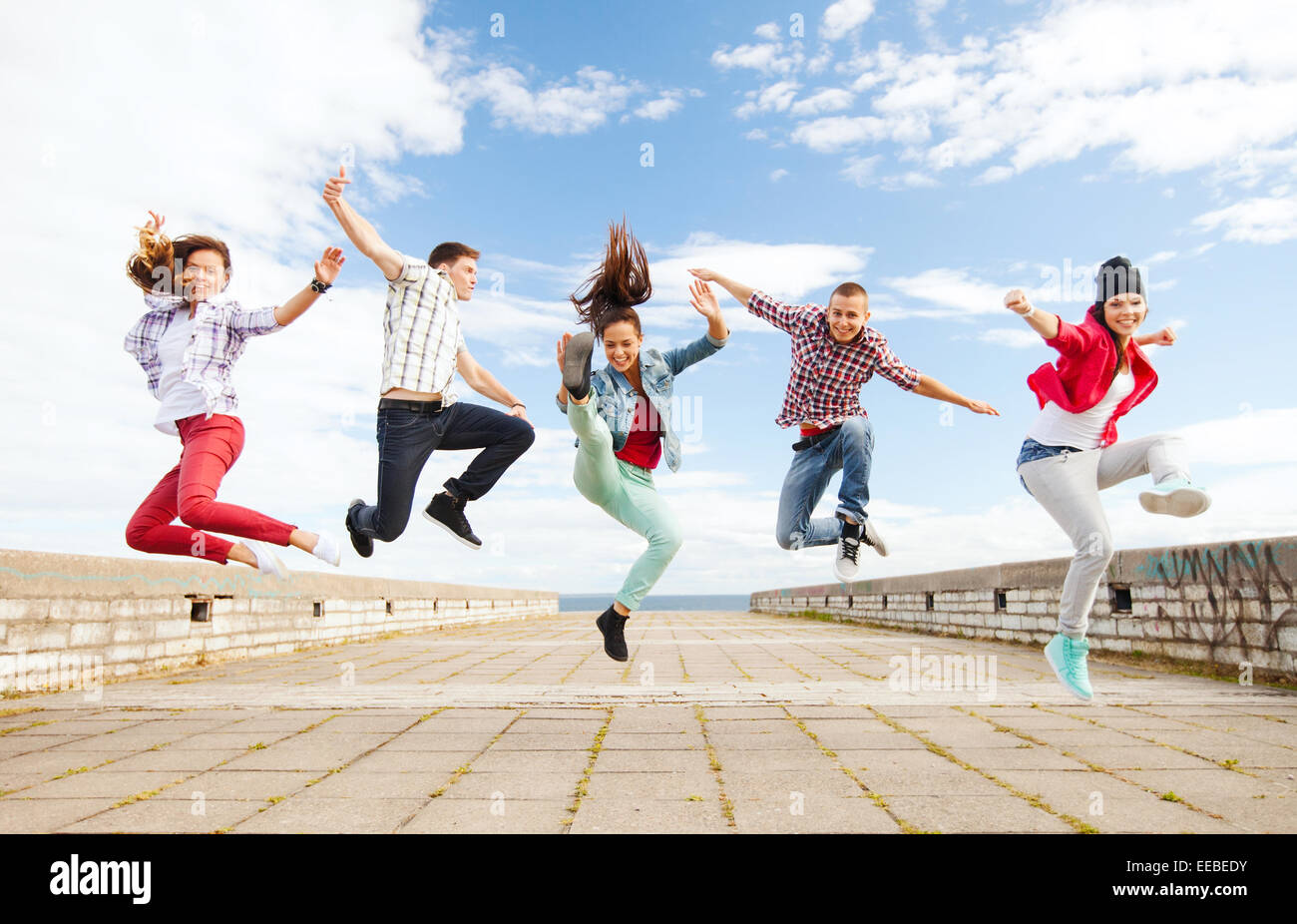 group of teenagers jumping Stock Photo - Alamy