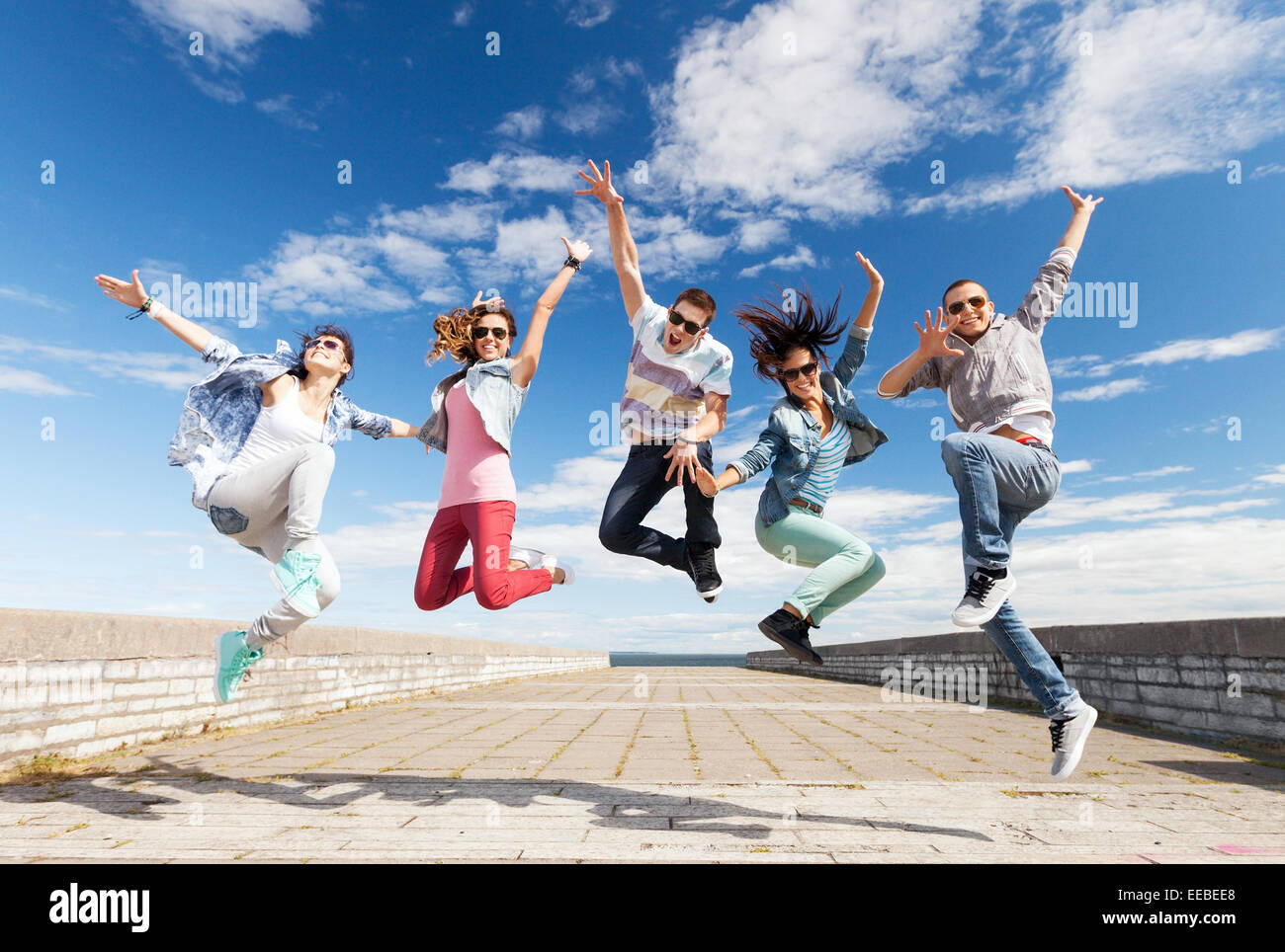 group of teenagers jumping Stock Photo - Alamy