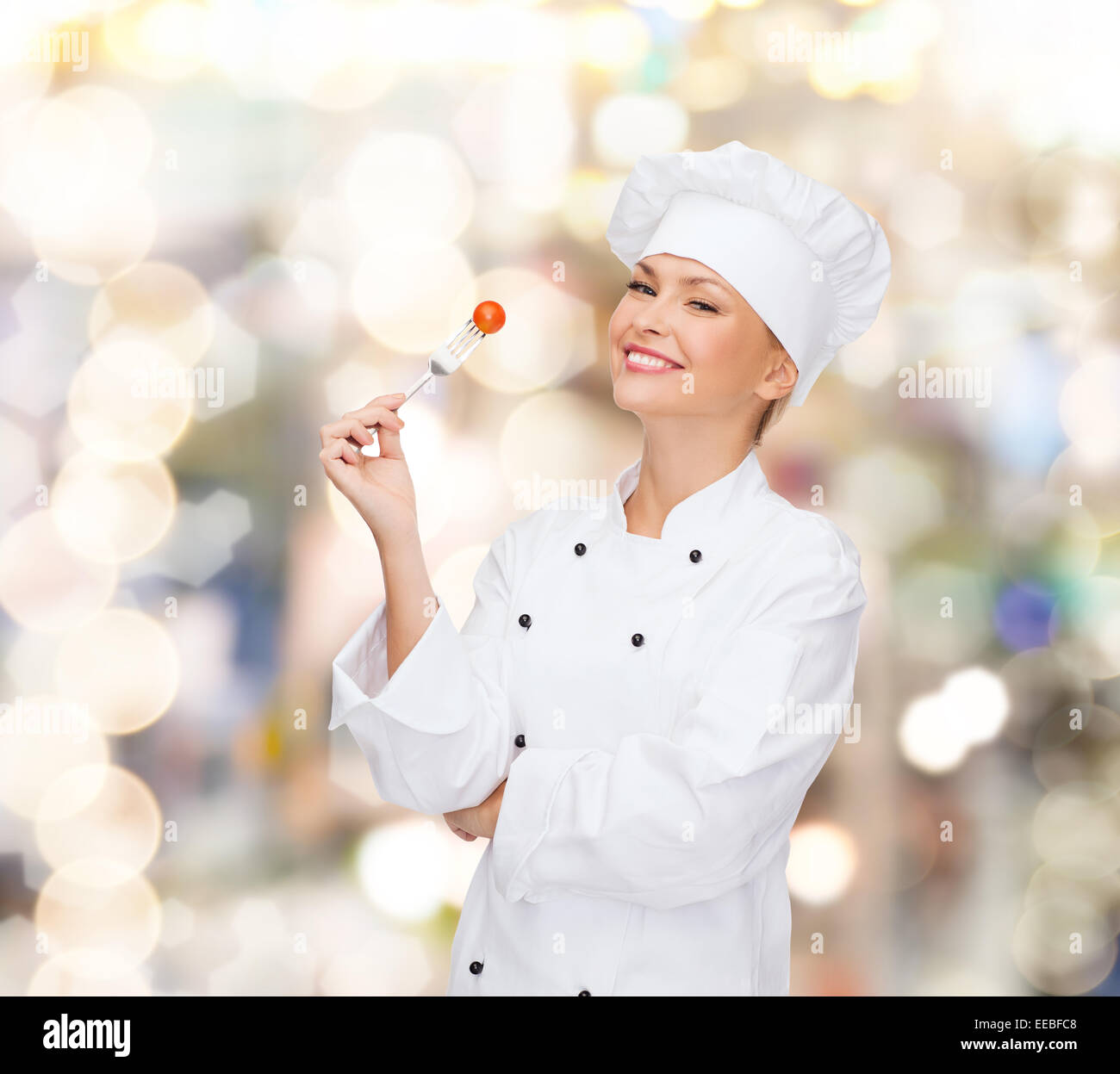 smiling female chef with fork and tomato Stock Photo - Alamy
