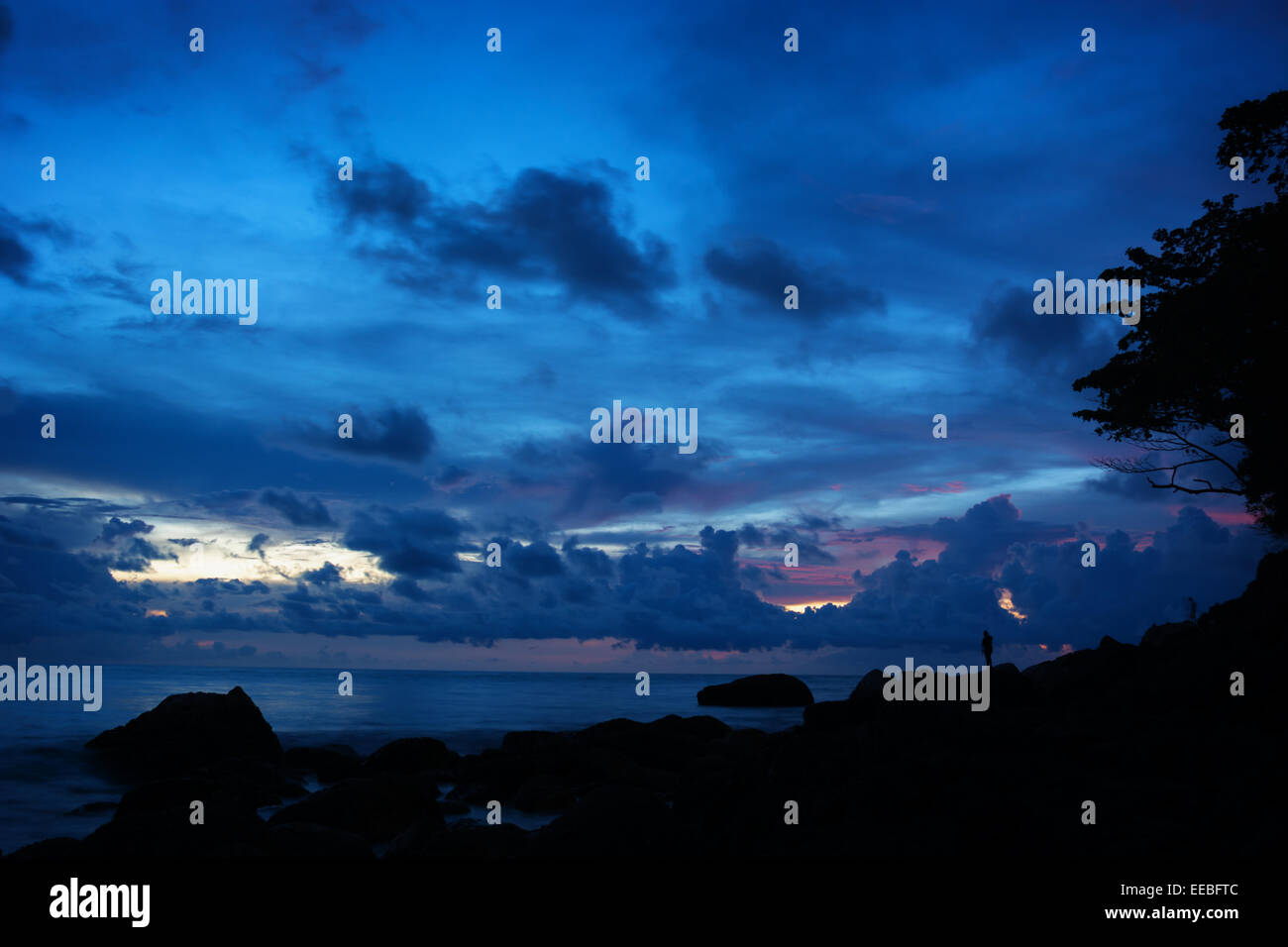 Deep blue skies at dusk accent the rocky, silhouetted landscape of a ...