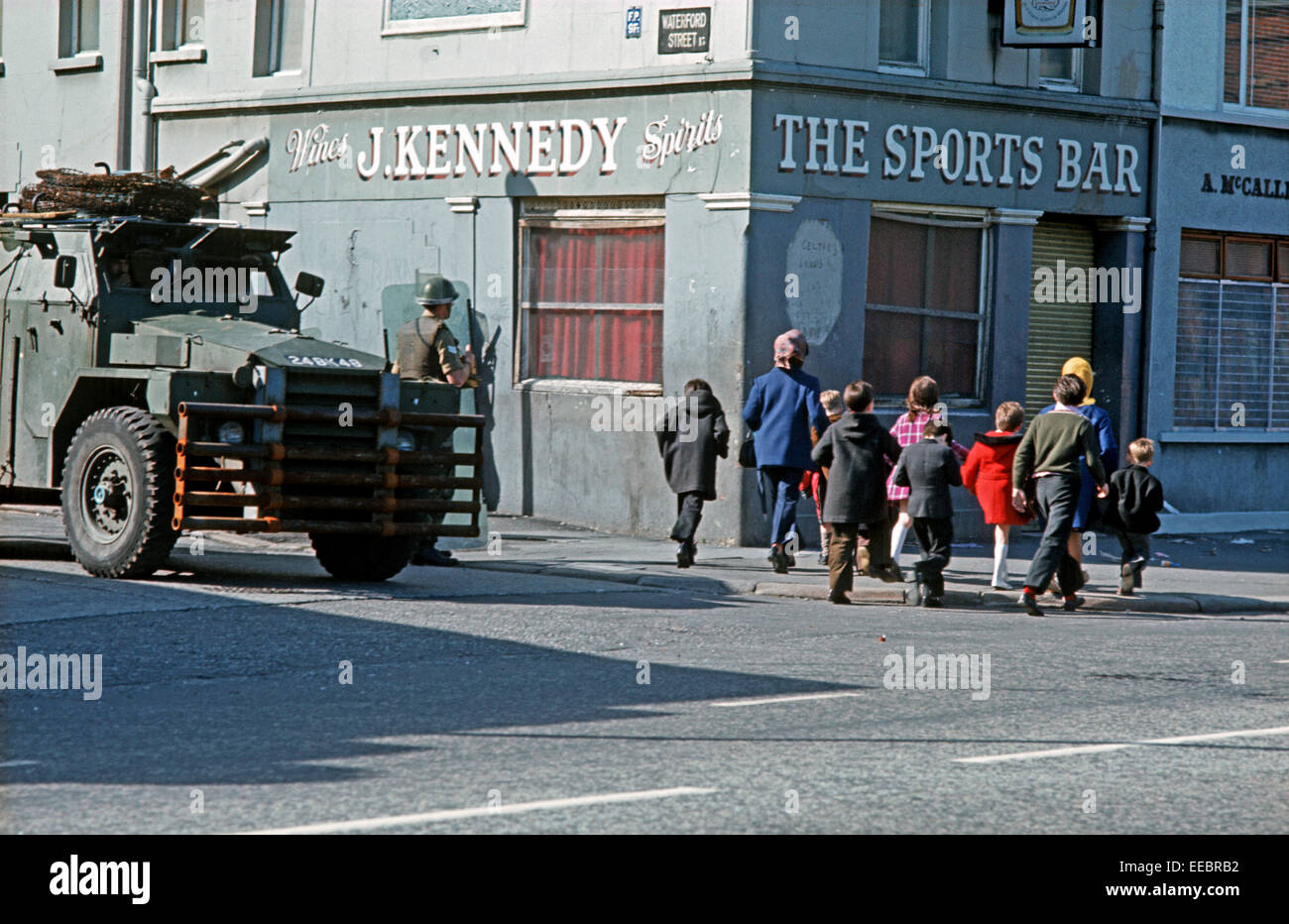 BELFAST, NORTHERN IRELAND - OCTOBER 1972. Families passing British Army ...