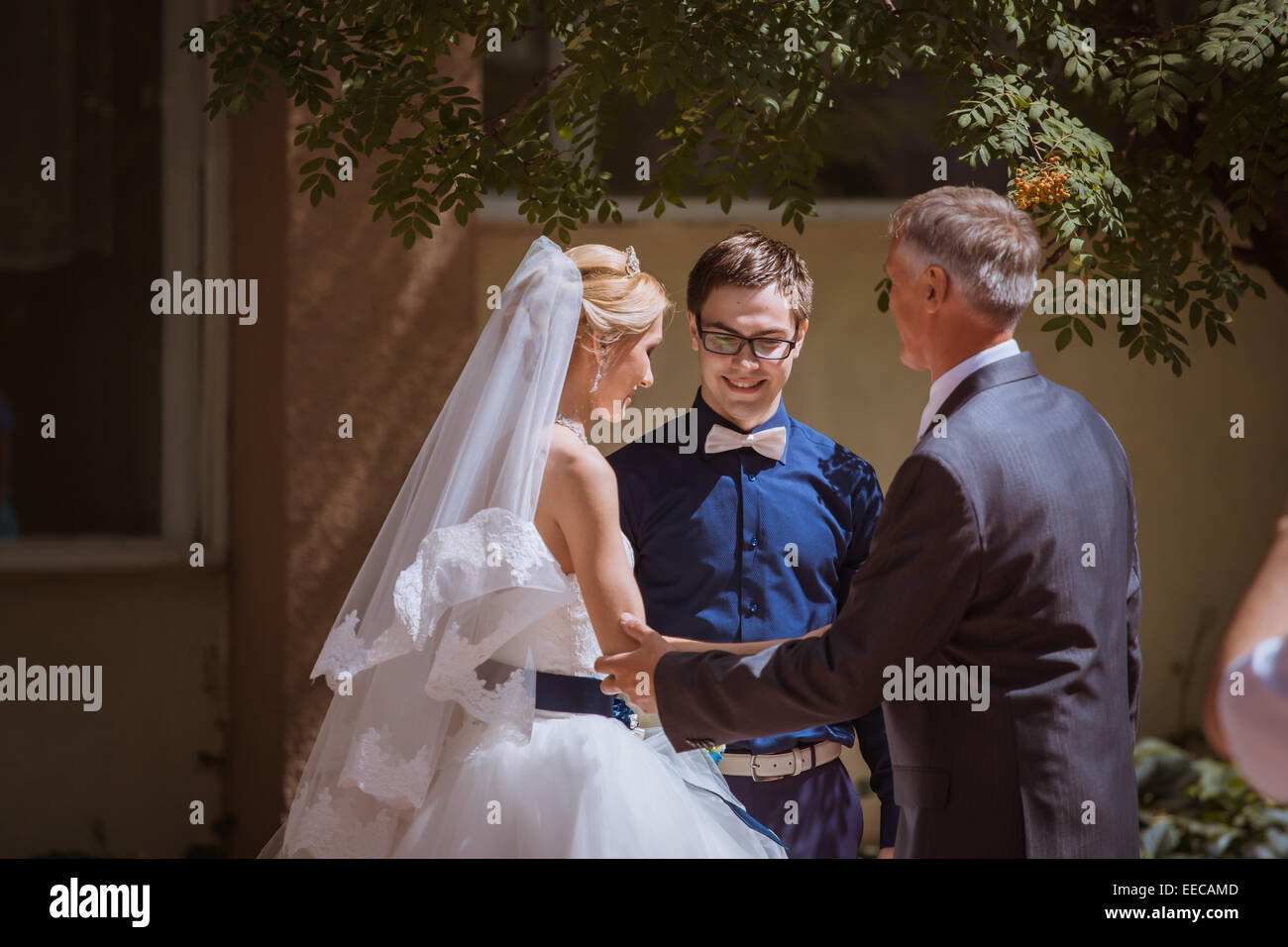 Bride and father with groom at beach wedding Stock Photo - Alamy