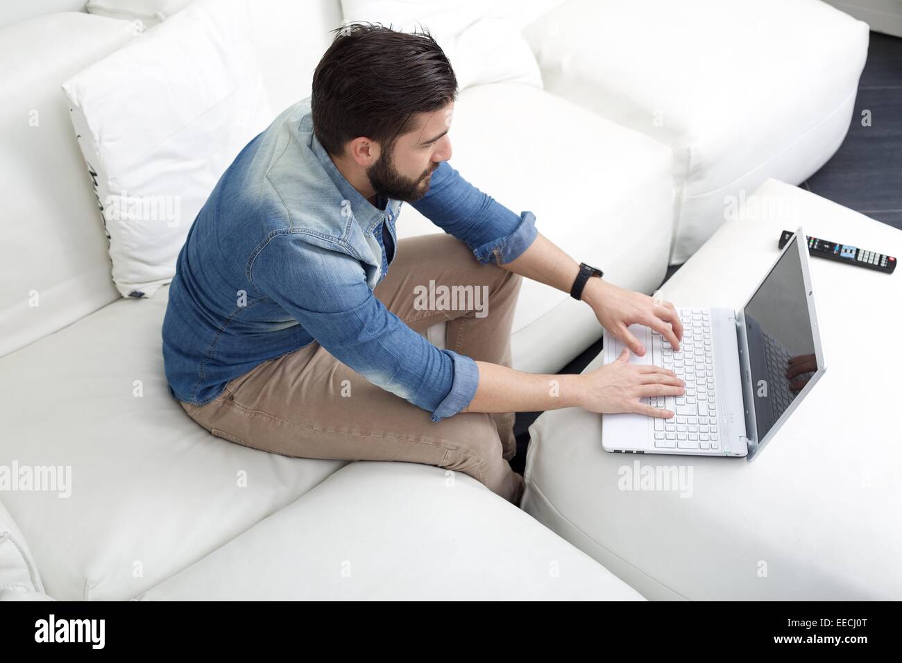 young man relaxing typing Stock Photo - Alamy