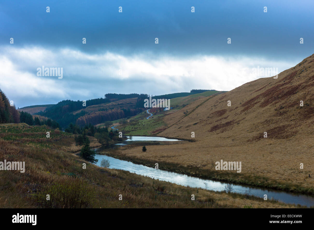 River runs along a valley in the Brecon Beacons mountain range in Wales ...