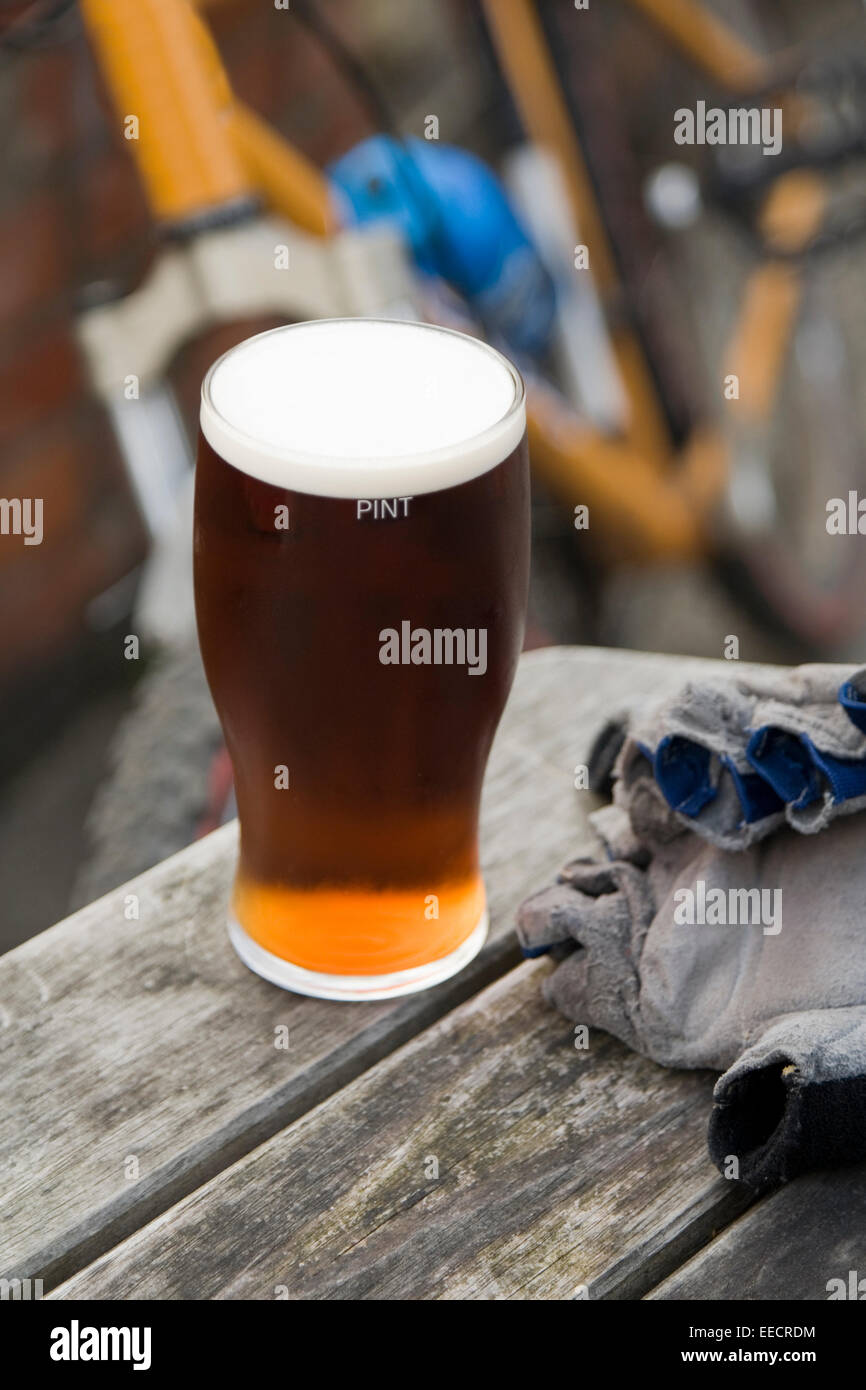 Welcome pint of beer bitter after mountain biking, with bike and gloves ...