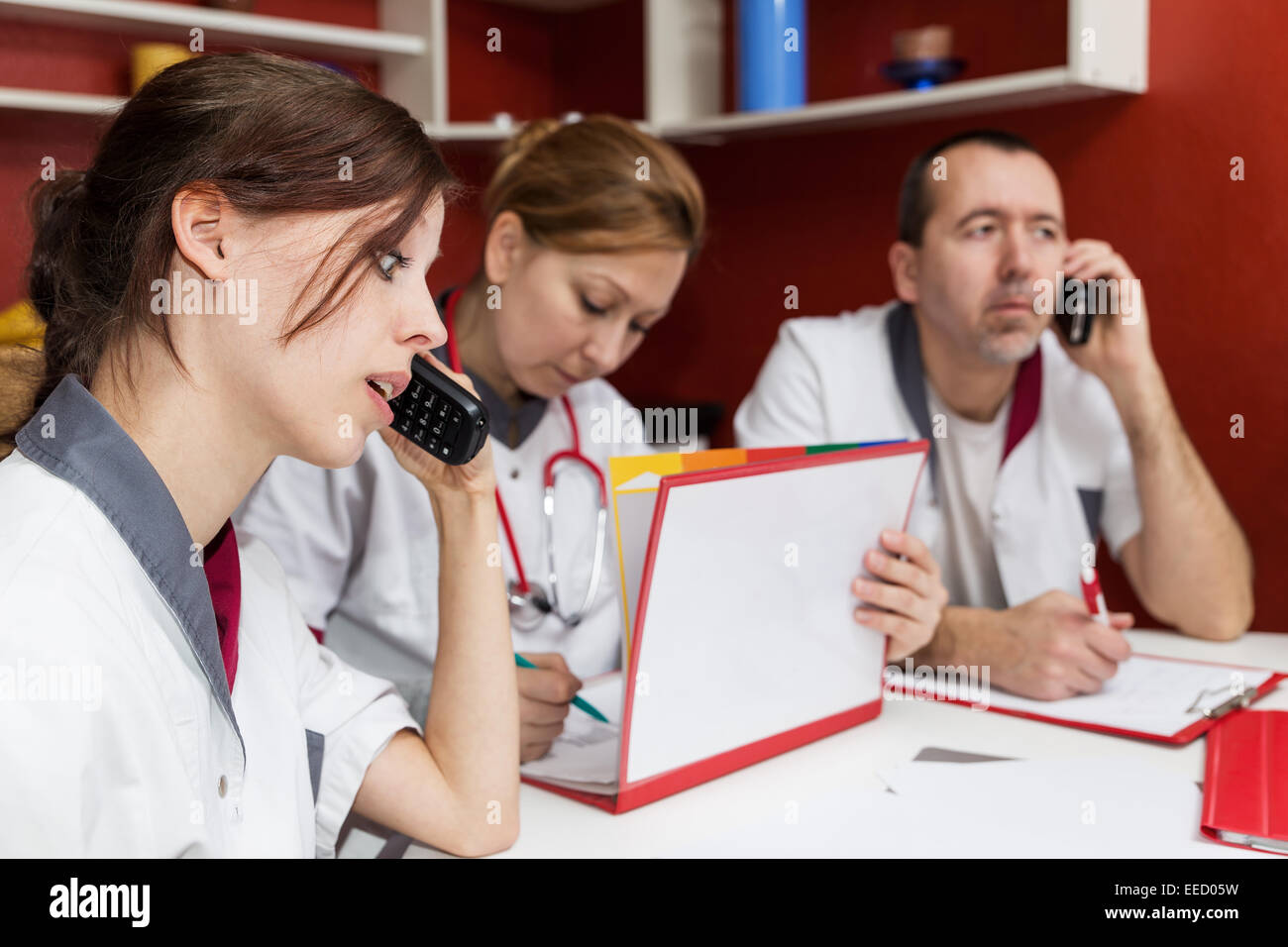 busy nurse staff is phoning, sitting on a round table Stock Photo - Alamy