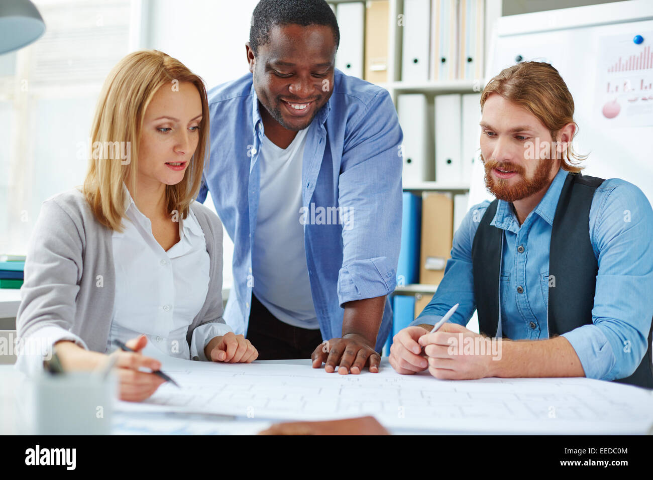 Group of architects discussing blueprint at meeting Stock Photo - Alamy