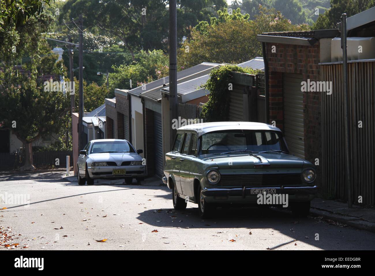 A vintage Australian car on a street behind a row of garages in the ...