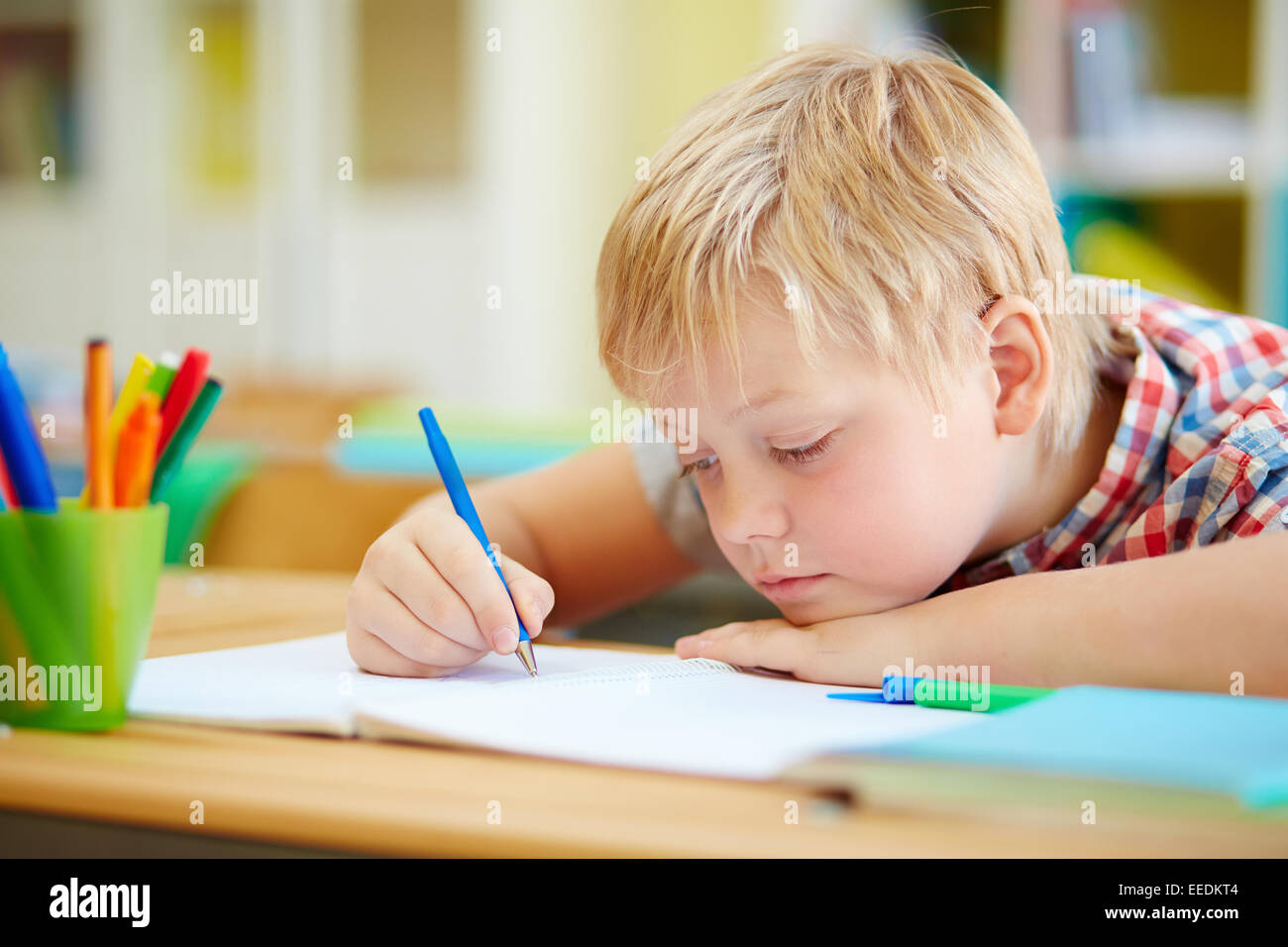 Youthful learner making notes or drawing with pen at lesson Stock Photo ...
