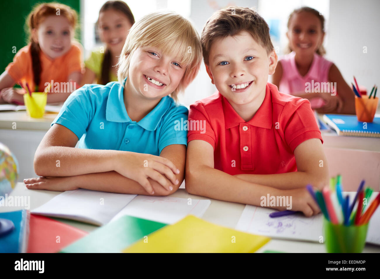 Two cheerful schoolboys looking at camera in classroom Stock Photo - Alamy