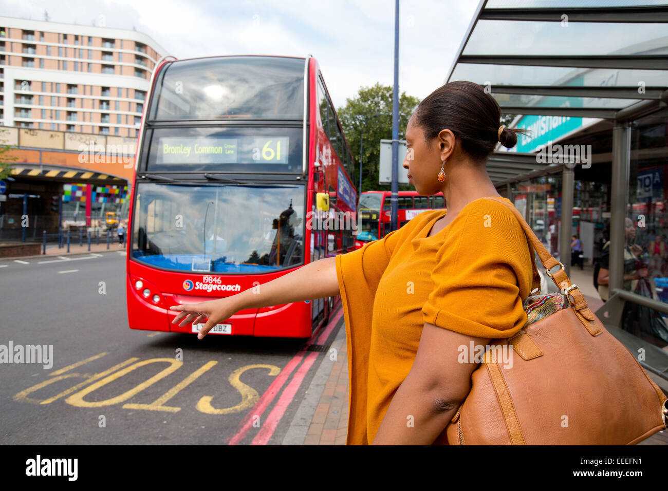 Woman hailing a London bus Stock Photo - Alamy