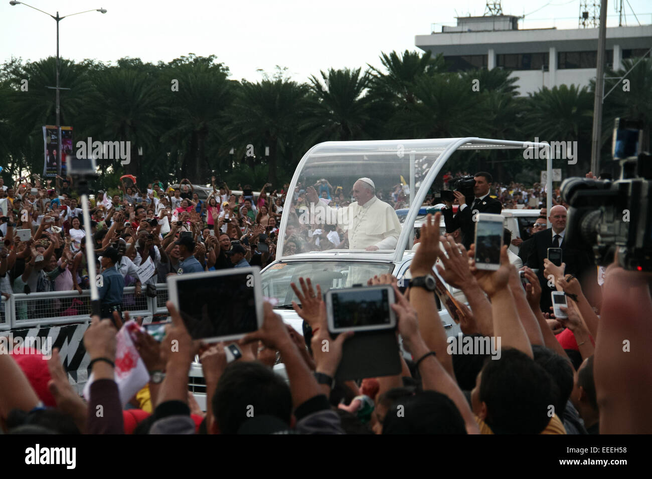 Pope Francis on the pope mobile waving to the crowd along Roxas ...