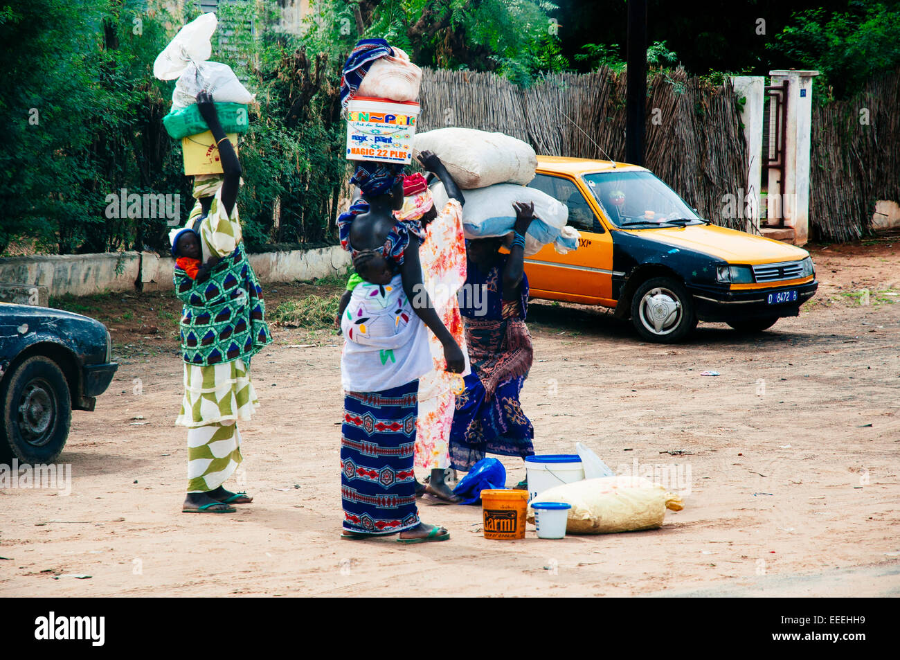 Women carrying big and heavy things on head while carrying her baby on ...