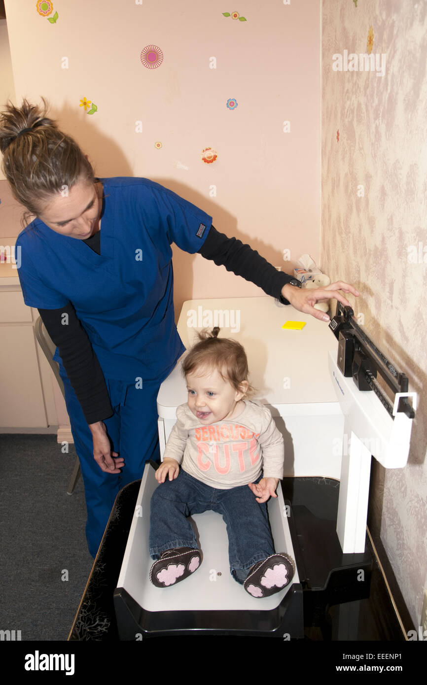health care professional weighing a child on a baby scale Stock Photo ...
