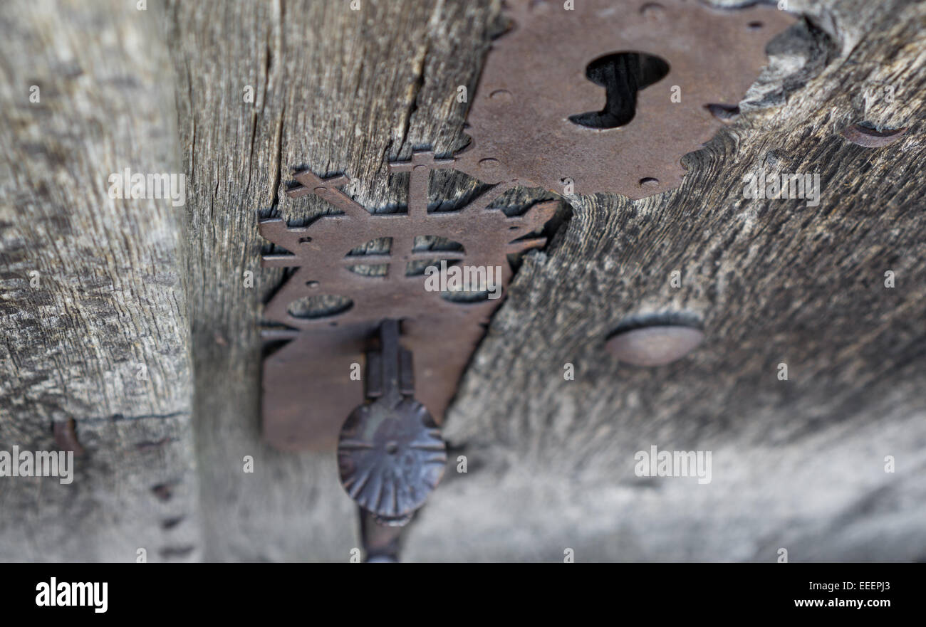 Run-down wooden door and decorated iron lock with crosses Stock Photo ...