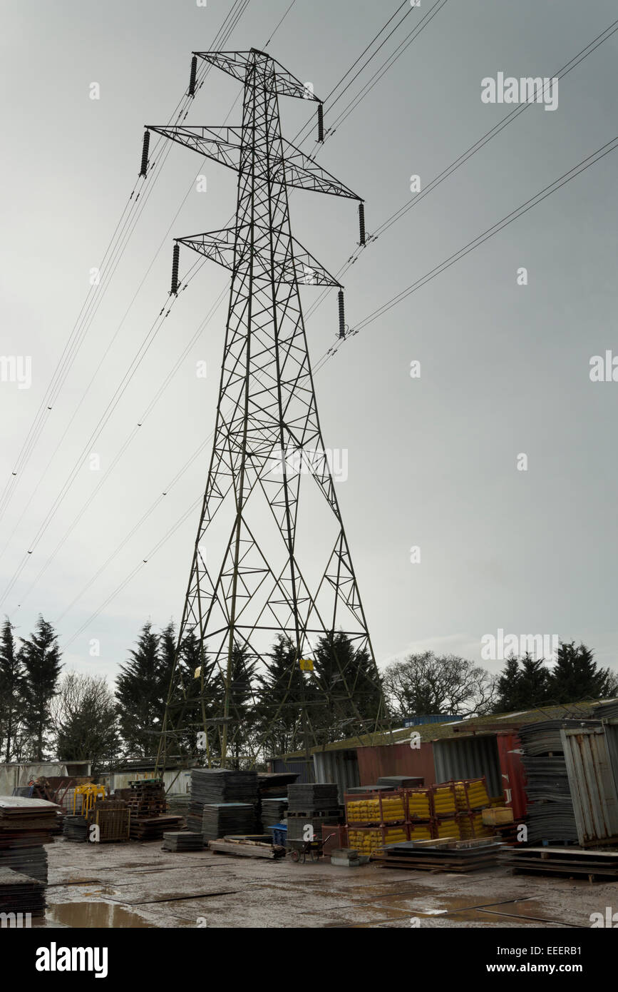 High voltage electricity pylon and industrial warehouse units below ...