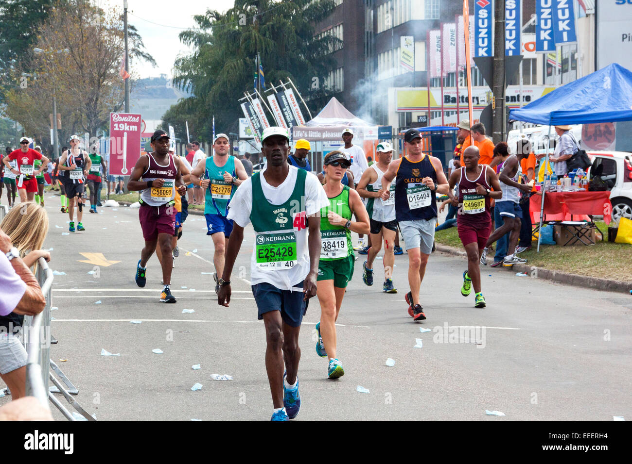 Spectators and Many runners competing in the long distance Comrades ...