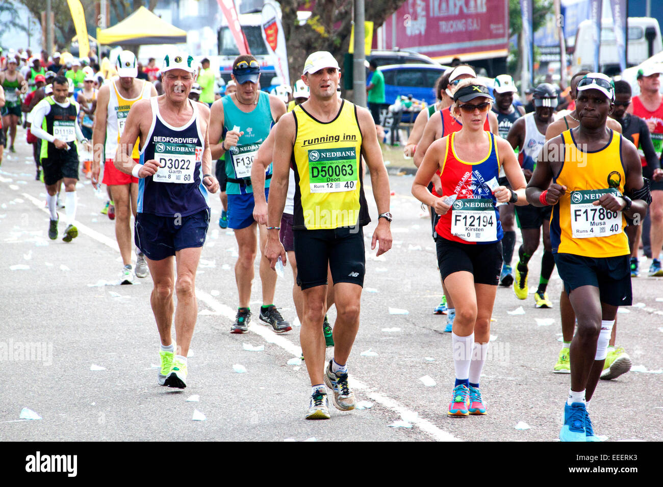 Spectators and runners competing in the long distance Comrades Marathon ...