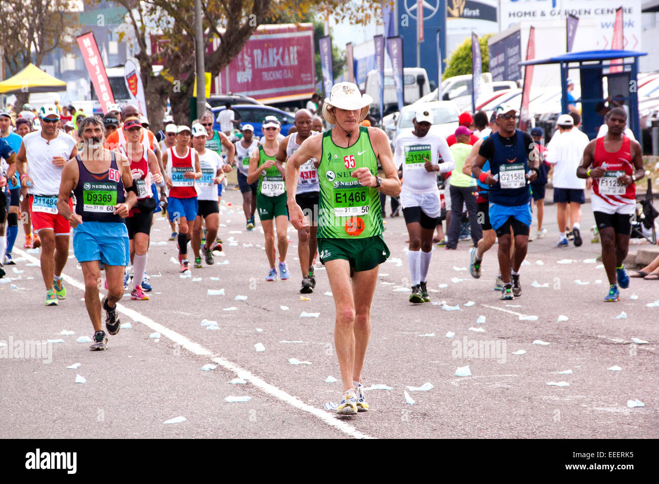 Spectators and runners competing in the long distance Comrades Marathon ...