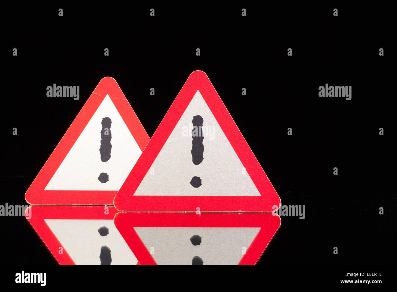 Danger warning signs on the black glass table Stock Photo - Alamy