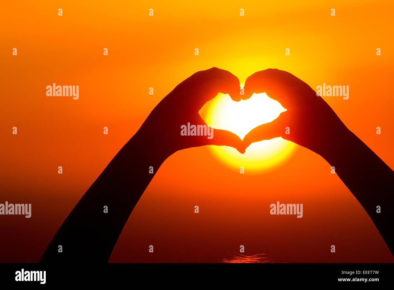 Hands making a heart shape in front of the sun Stock Photo - Alamy