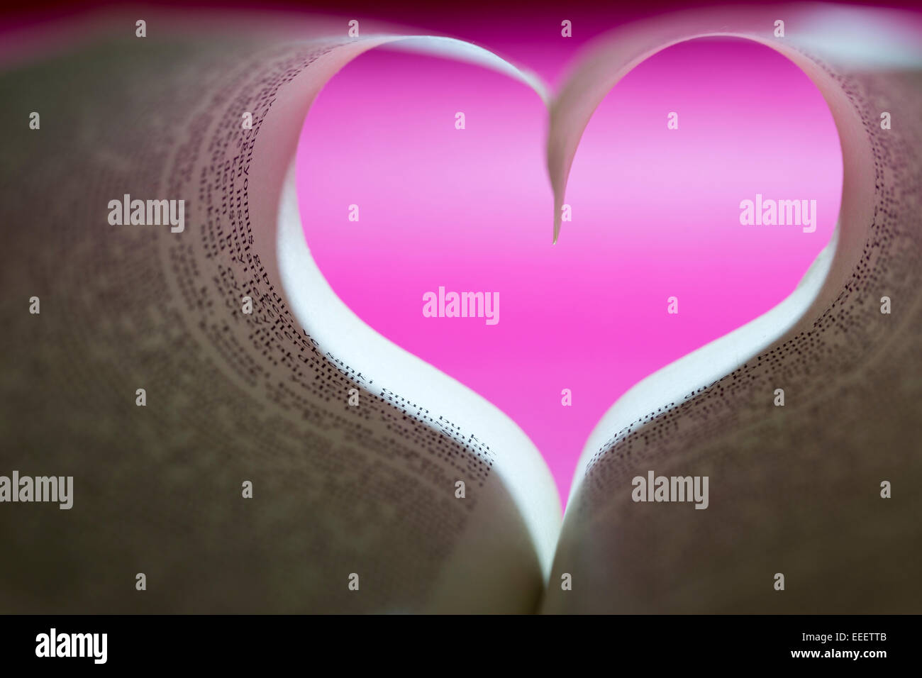 Sheets of a book heart shaped with pink color background Stock Photo ...