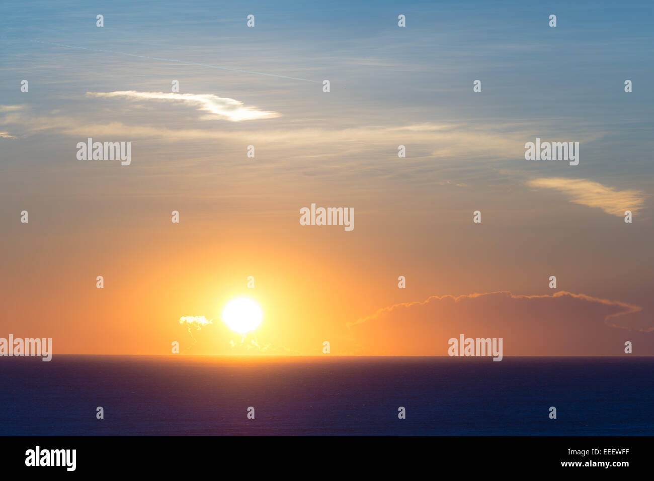 The rising sun on the horizon over deep blue sea. Romantic multi ...