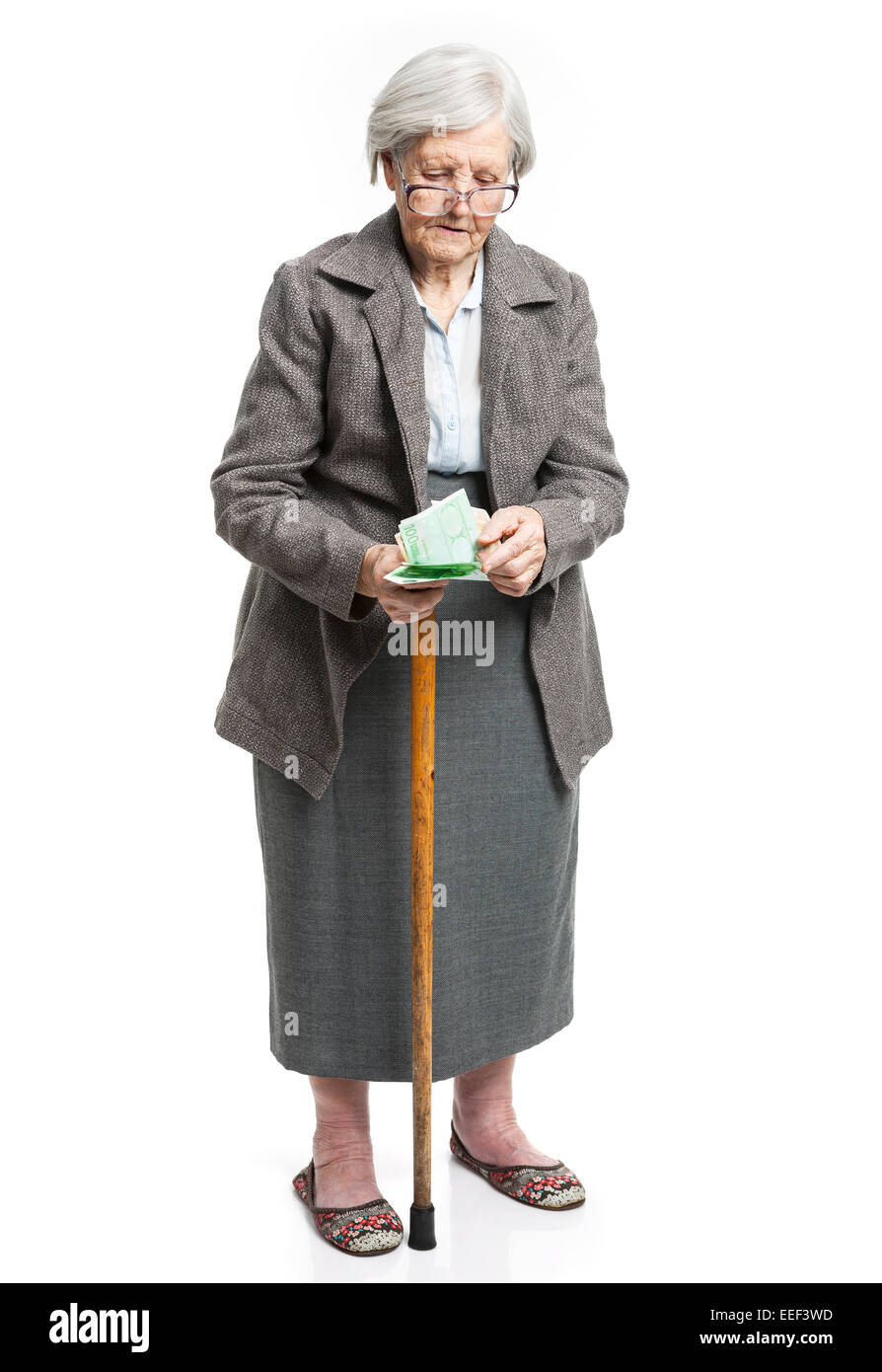 Senior woman counting money while standing over white background Stock ...
