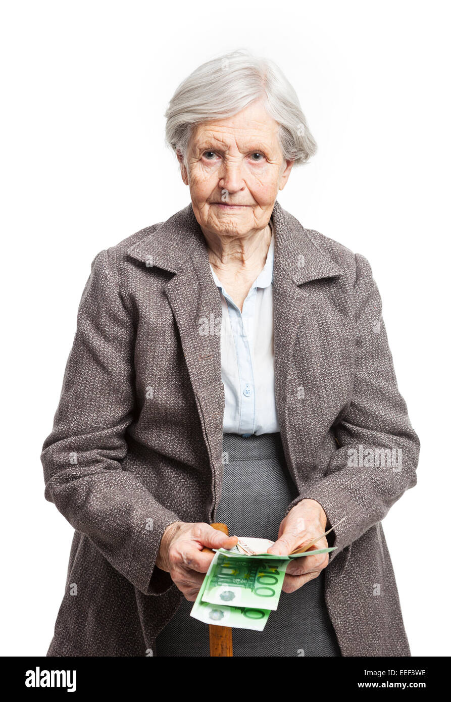 Senior woman counting money while standing over white background Stock ... Senior woman counting money while standing over white background Stock ...