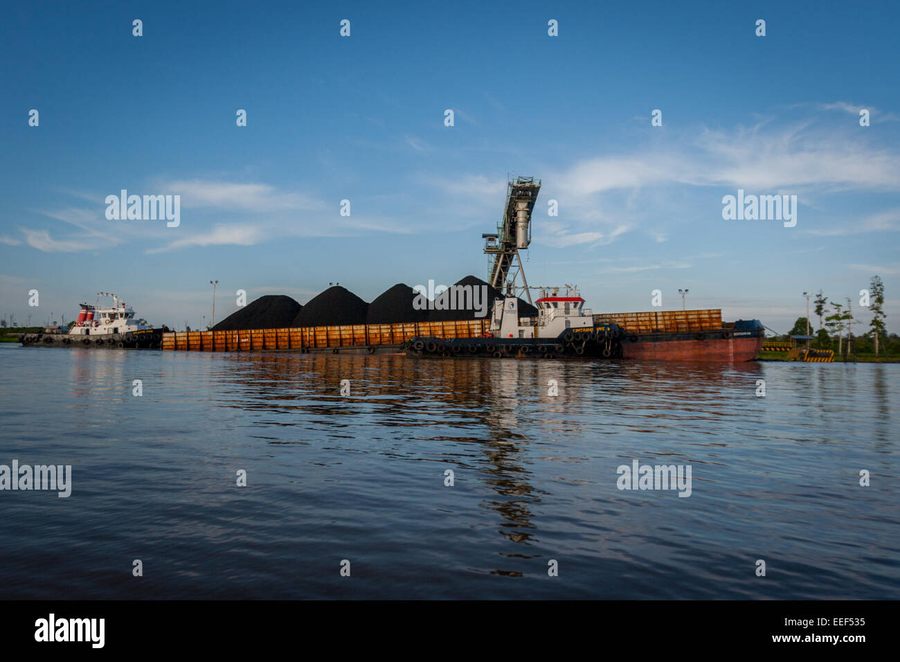 Coal barge at pile station on Mahakam River, East Kalimantan, Indonesia ...