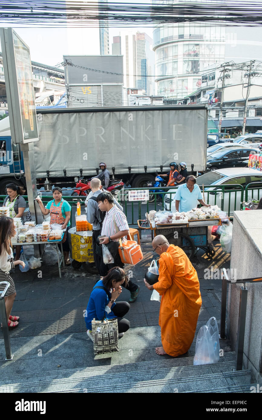 Buddhist monk at Ashok/Sukhumvit junction begging for food receiving ...