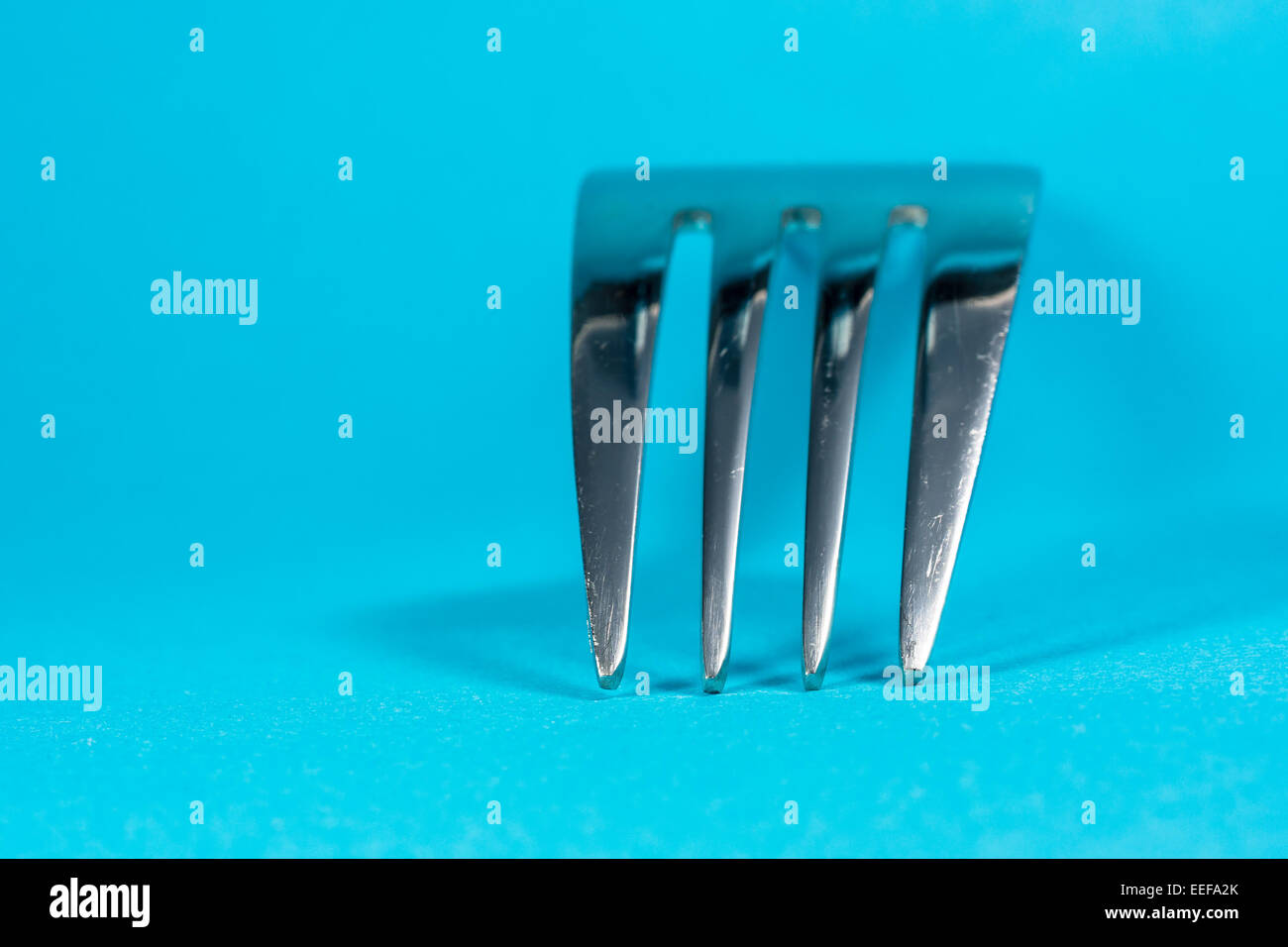 A fork isolated with blue background Stock Photo - Alamy